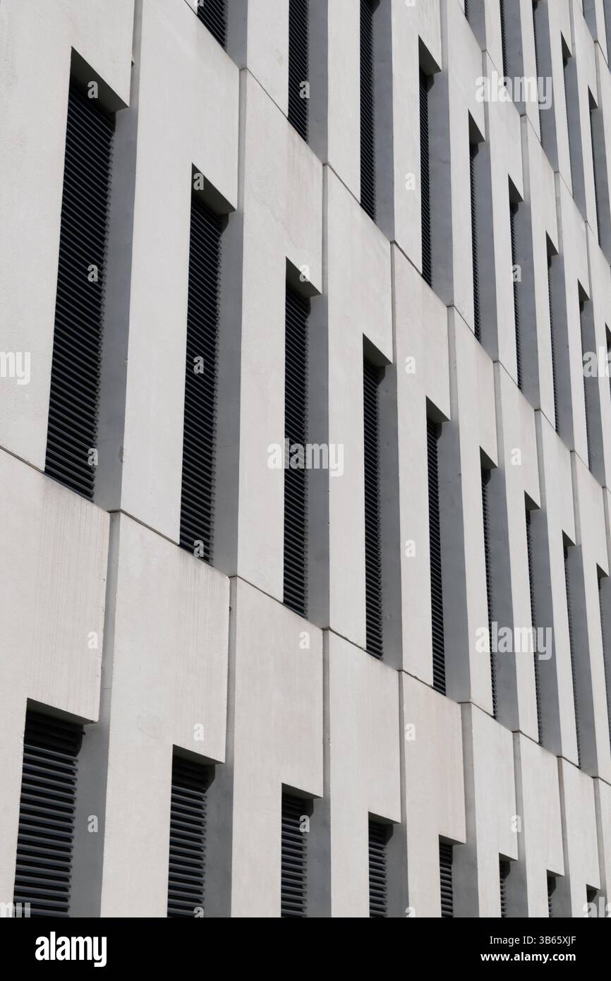 Modern building facade featuring vertical narrow windows set between ...