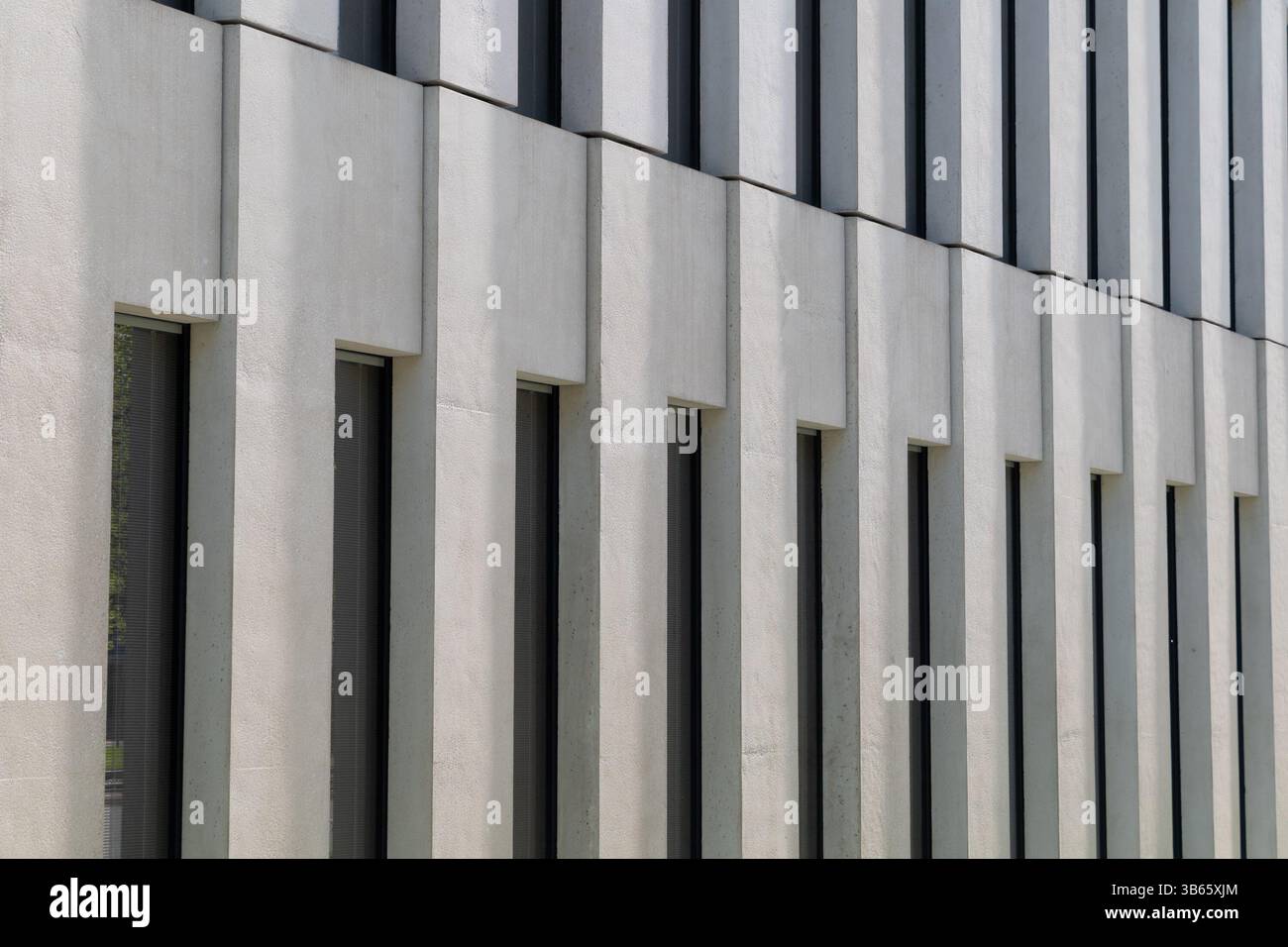 Modern building facade featuring vertical narrow windows set between ...