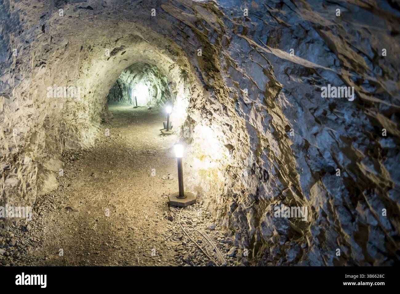 Mining tunnel in stone rock. Cave tunnel with lights. Underground mine ...
