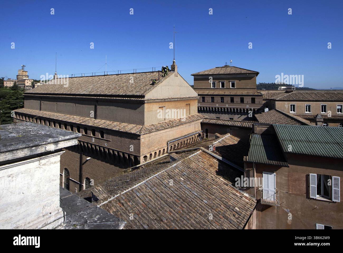 Vatican's firefighters setup the chimney on the roof of the Sistine ...