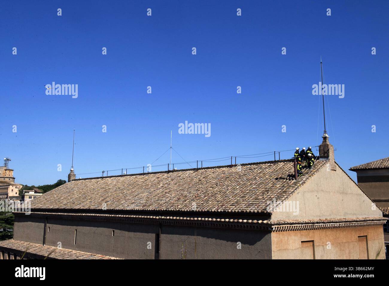 Vatican's firefighters setup the chimney on the roof of the Sistine ...