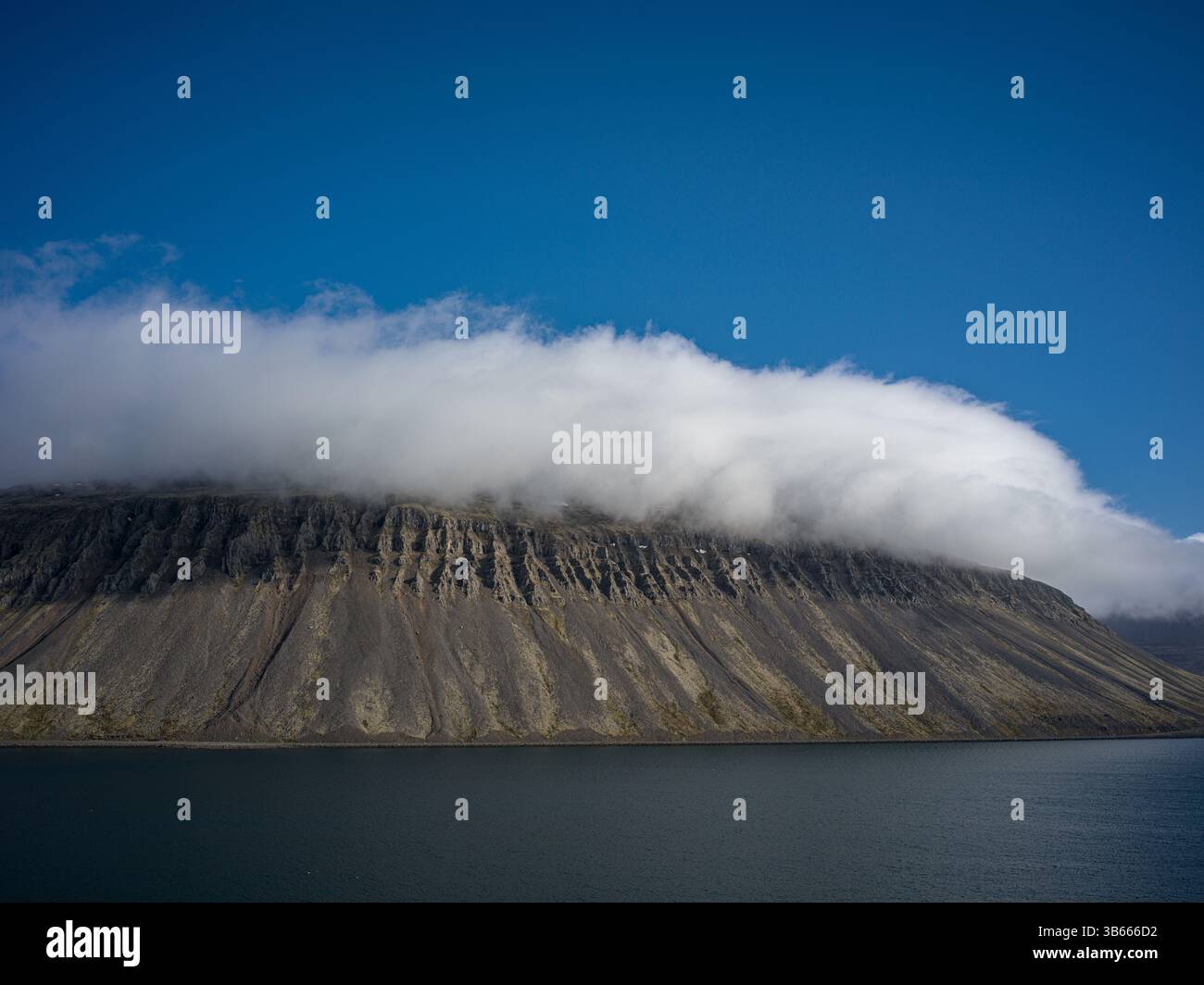 Low clouds sweeping over a basalt plateau near Patreksfjörður ...