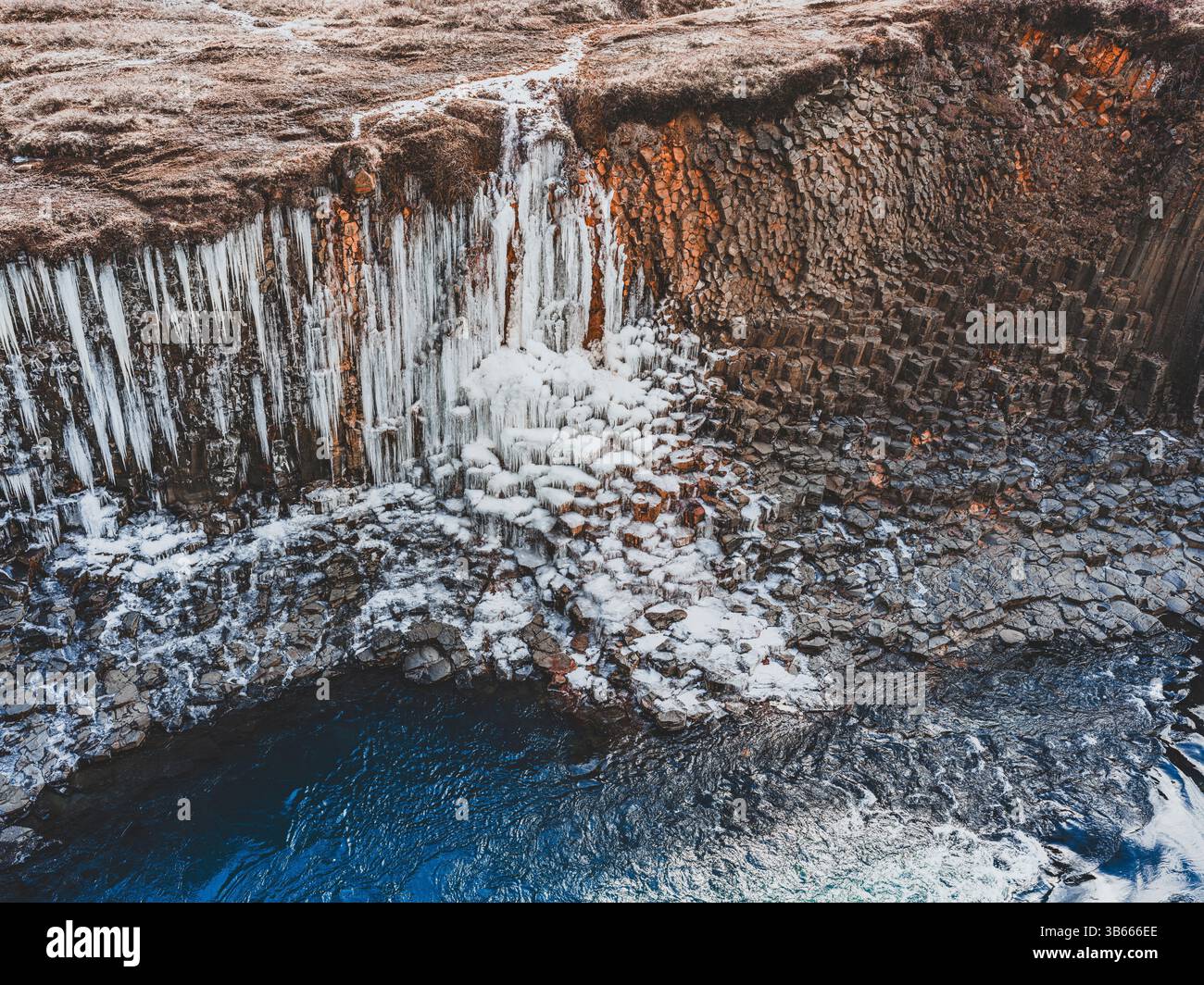 Turquoise glacial river flowing through basalt columns at Stuðlagil ...