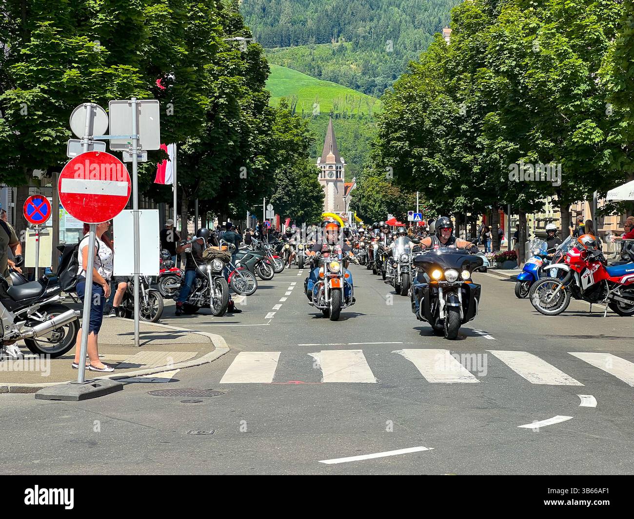 Many bikers ride motorcycles along the main street of the city in ...