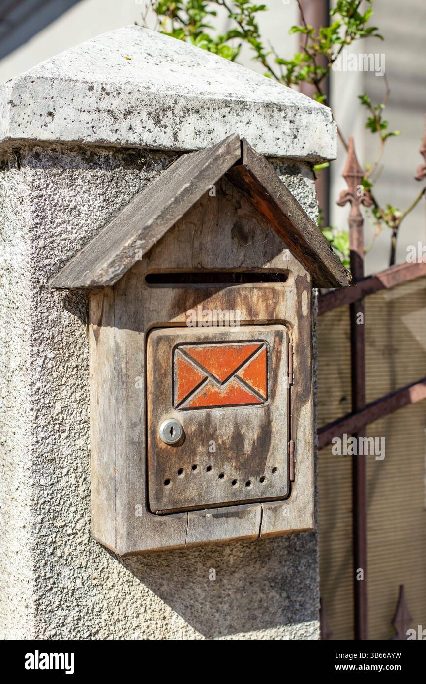 Weathered wooden parcel post box on a cement fence pole Stock Photo - Alamy