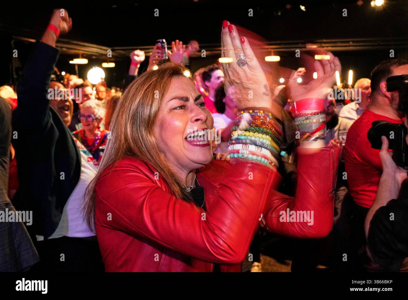 Labor Party supporters react as they watch results shown on a screen at ...
