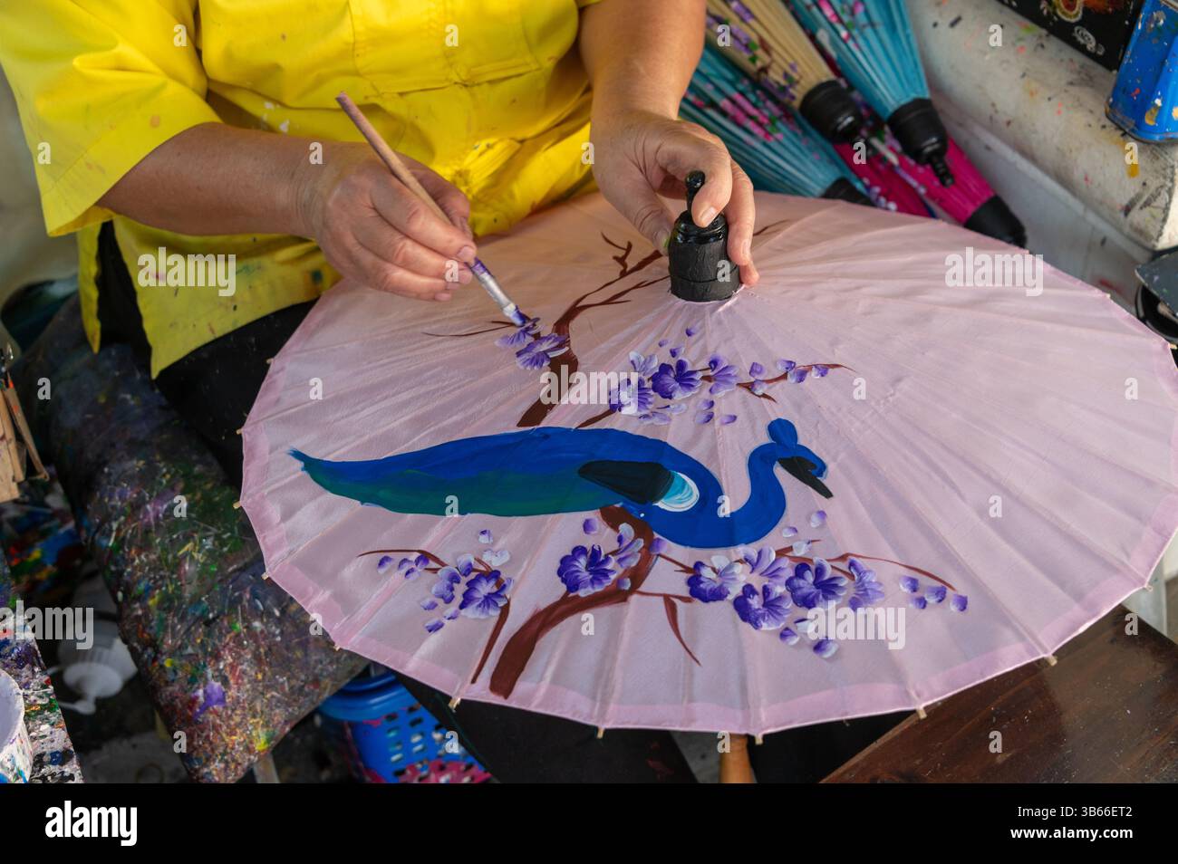An artist painting an umbrella at the Bo Sang Umbrella village in Chiang Mai, Thailand Stock ...