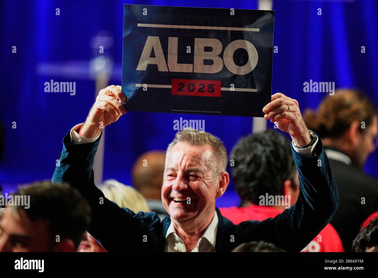 A Labor Party supporter reacts as he watches results shown on a screen ...
