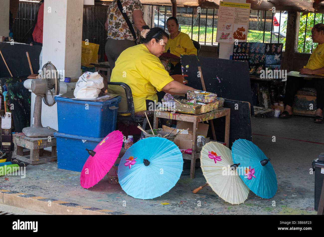 An artist painting an umbrella at the Bo Sang Umbrella village in Chiang Mai, Thailand Stock ...