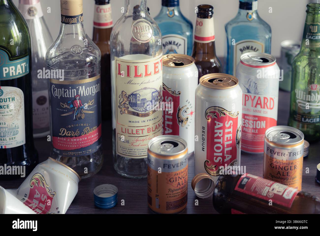 Desaturated image of empty beer cans and spirit bottles on a kitchen ...