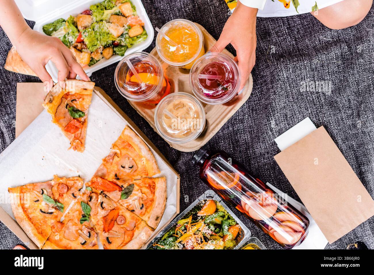 Hands taking slices of pizza close view. Friends eating pizza at the ...