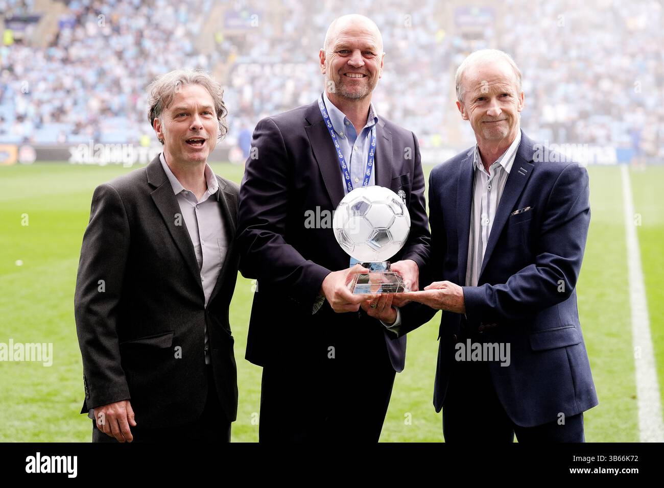 Dave Busst (centre) is presented with an award from the PFA at half ...