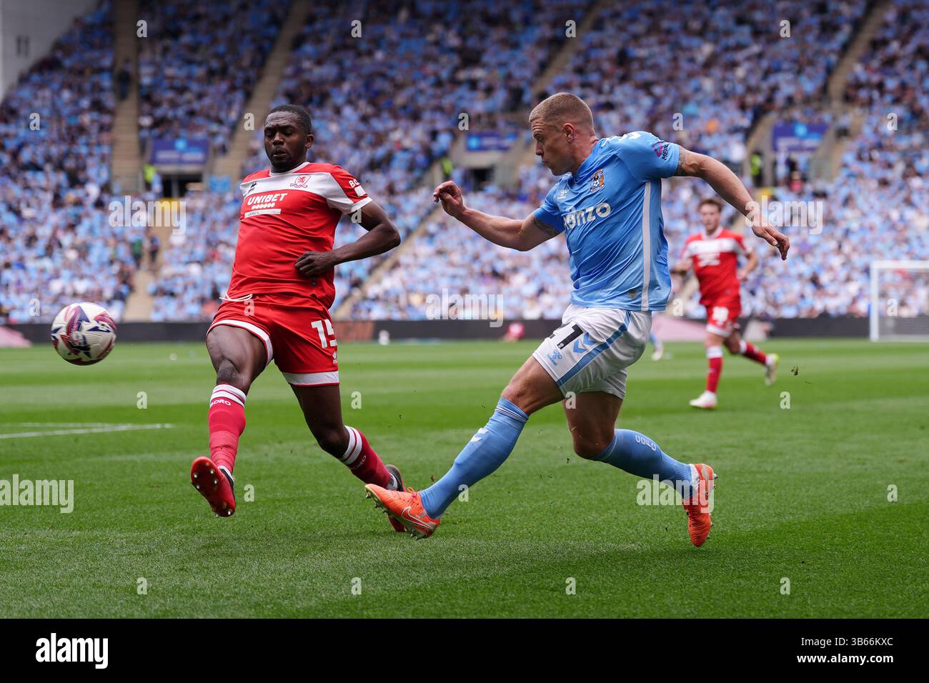 Coventry City's Jake Bidwell (right) crosses the ball under pressure ...