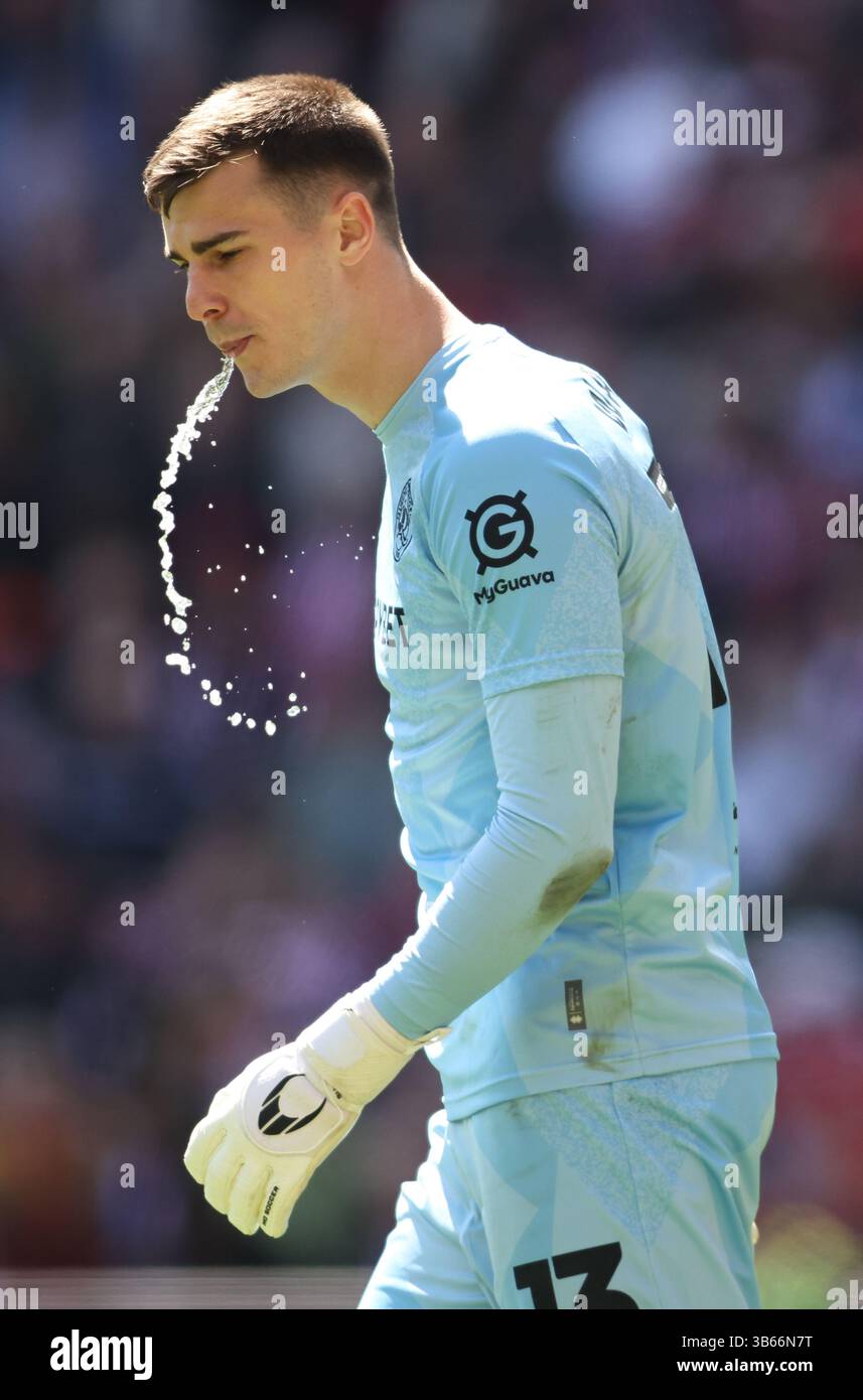 Queens Park Ranger's Goalkeeper Joe Walsh sprays water from his mouth ...