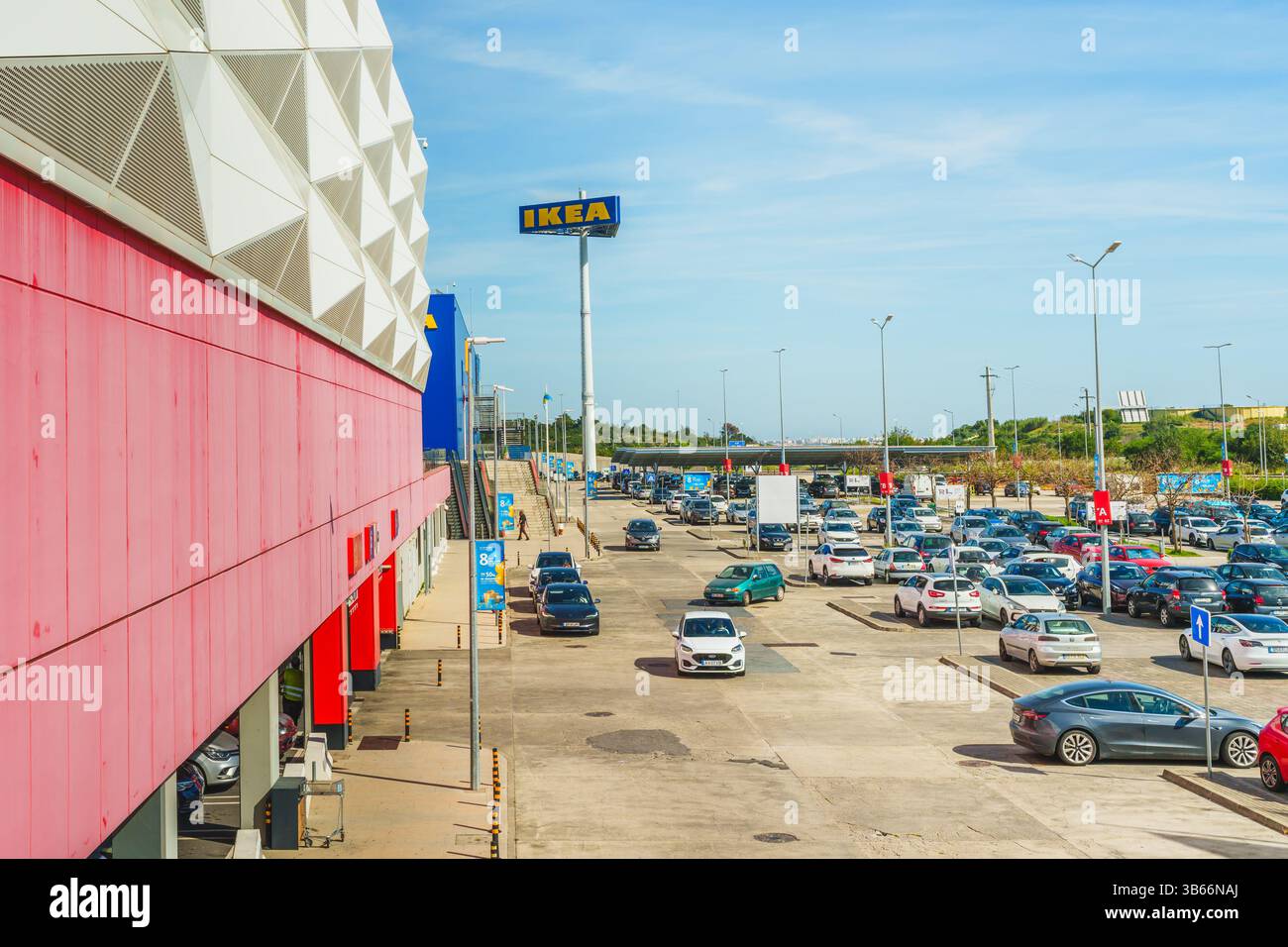 Loule, Portugal- April 27, 2025. View of IKEA storefront and adjacent parking lot filled with ...