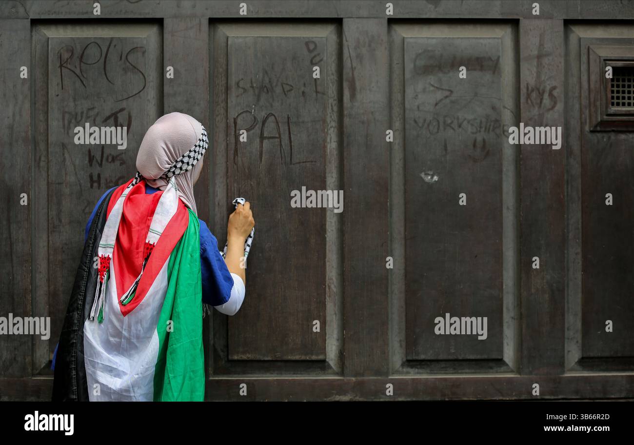 A protester writes Pal Action in the dirt on the van entrance to.the ...