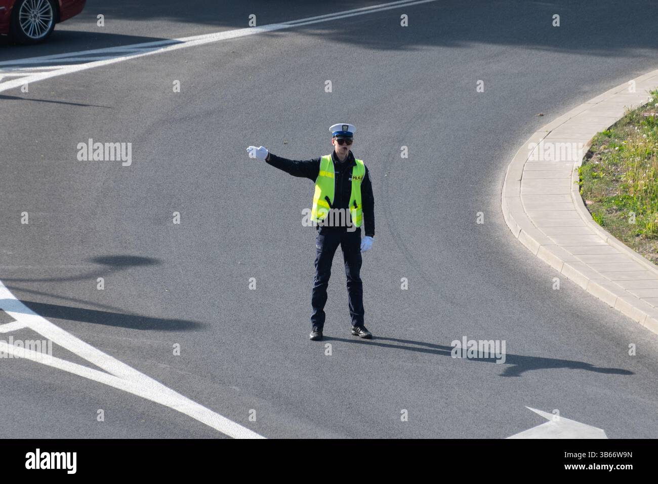 Male traffic police officer directing vehicles on urban roadway. Warsaw ...