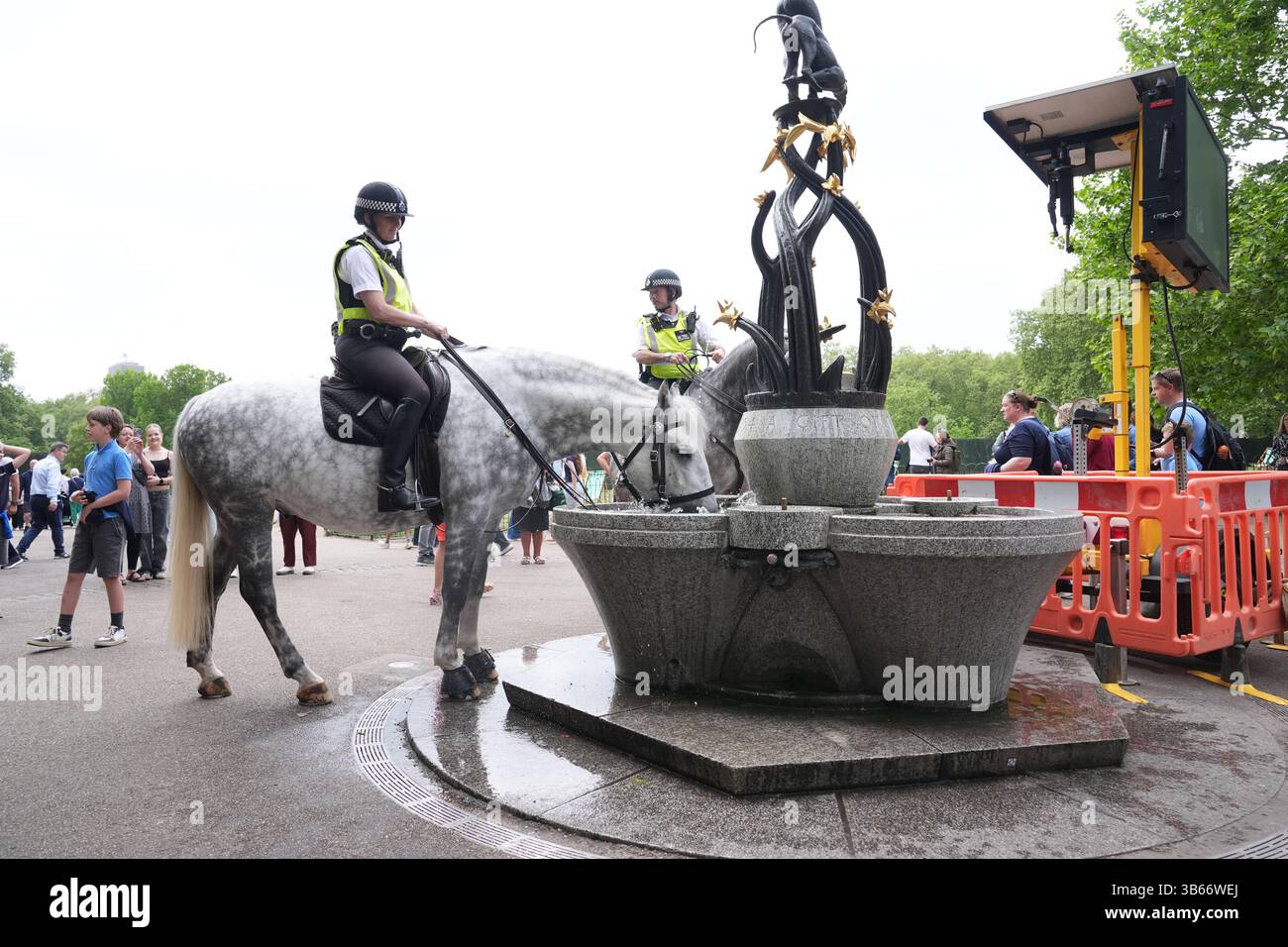 Police horses drink from a foundation in Green Park, London, as the ...