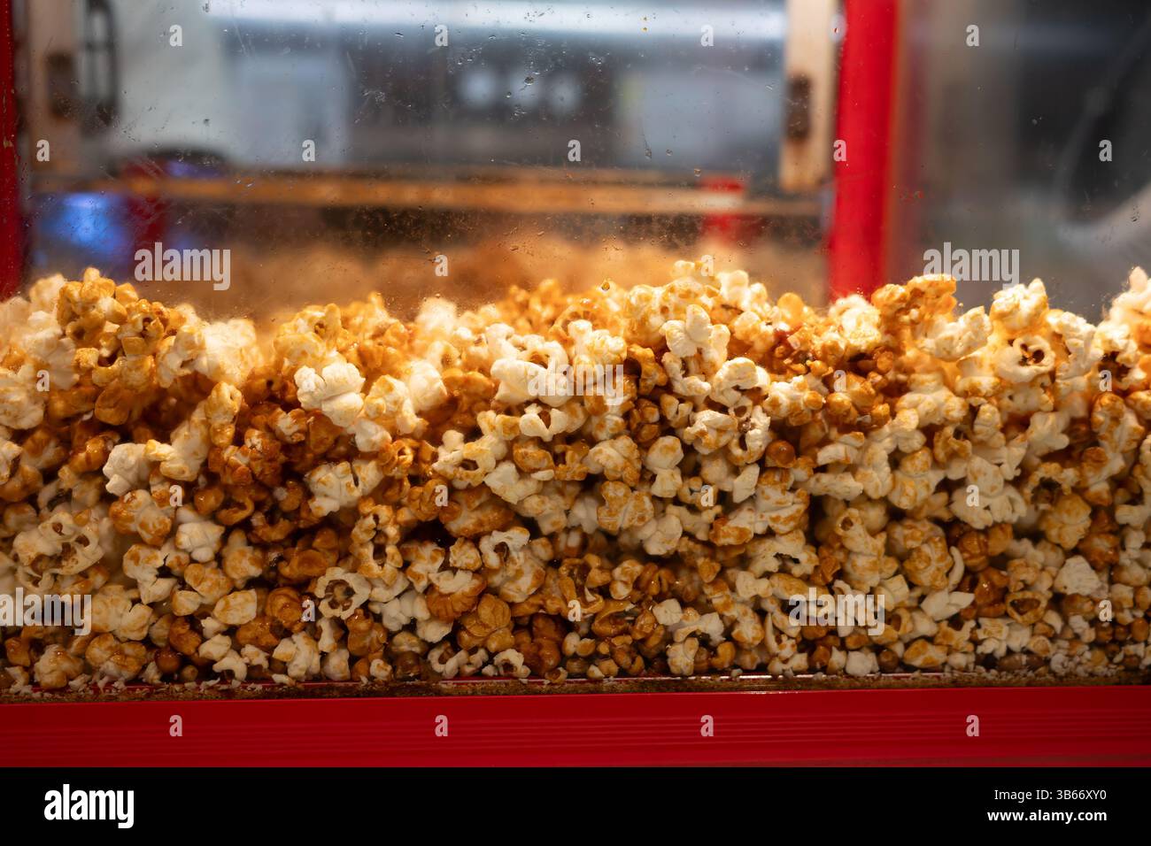 Caramel popcorn freshly cooked in glass street food ready for packing ...