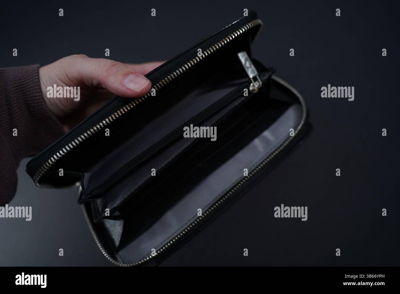 A hand hold an open old empty wallet,black background Stock Photo - Alamy