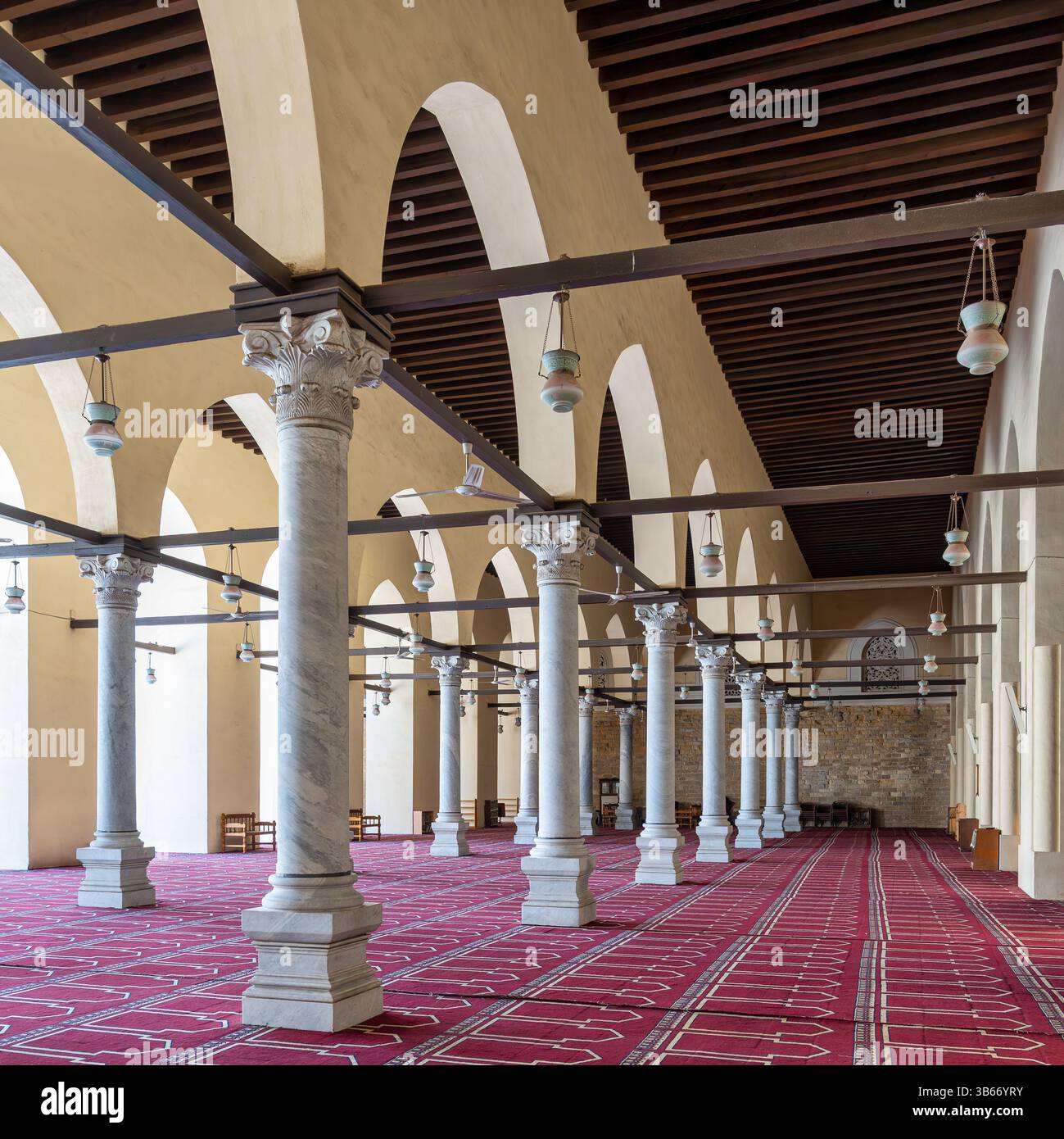 The Al-Zahir Baybars Mosque in Cairo features tall columns, arched passages, and a decorated ...