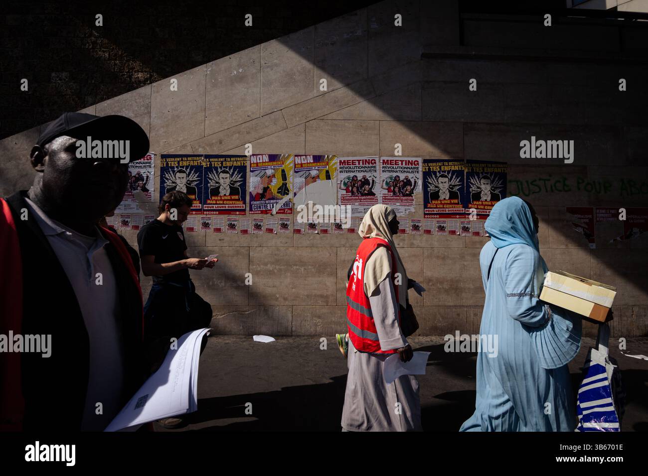 Paris, France. 01st May, 2025. Muslim women and CGT trade unionists pass in front of anti-Macron ...