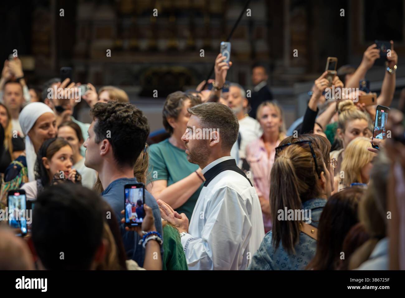 Vatican City - April 30, 2025: A priest passes among the faithful, who ...