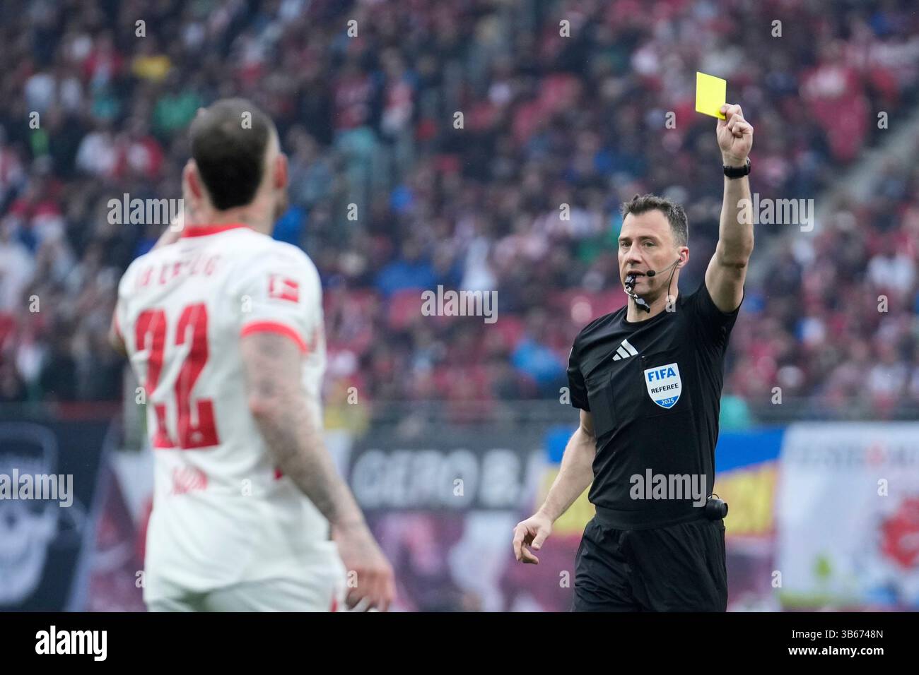 Referee Felix Zwayer shows a yellow card to Leipzig's David Raum during ...