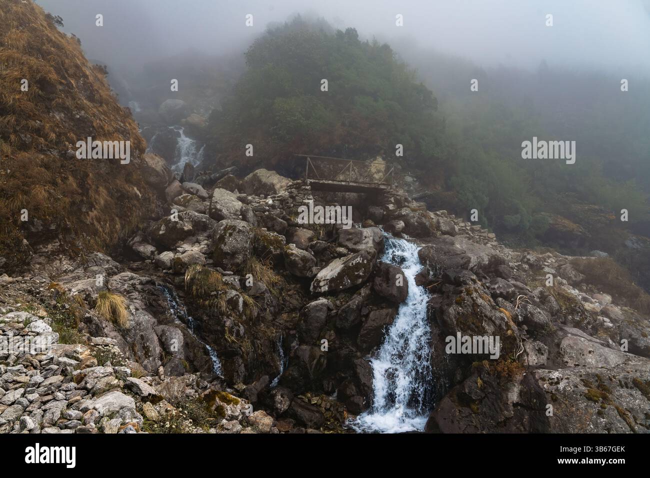 Beautiful Himalayan Glacial Waterfalls in the Mountains with a Bridge ...