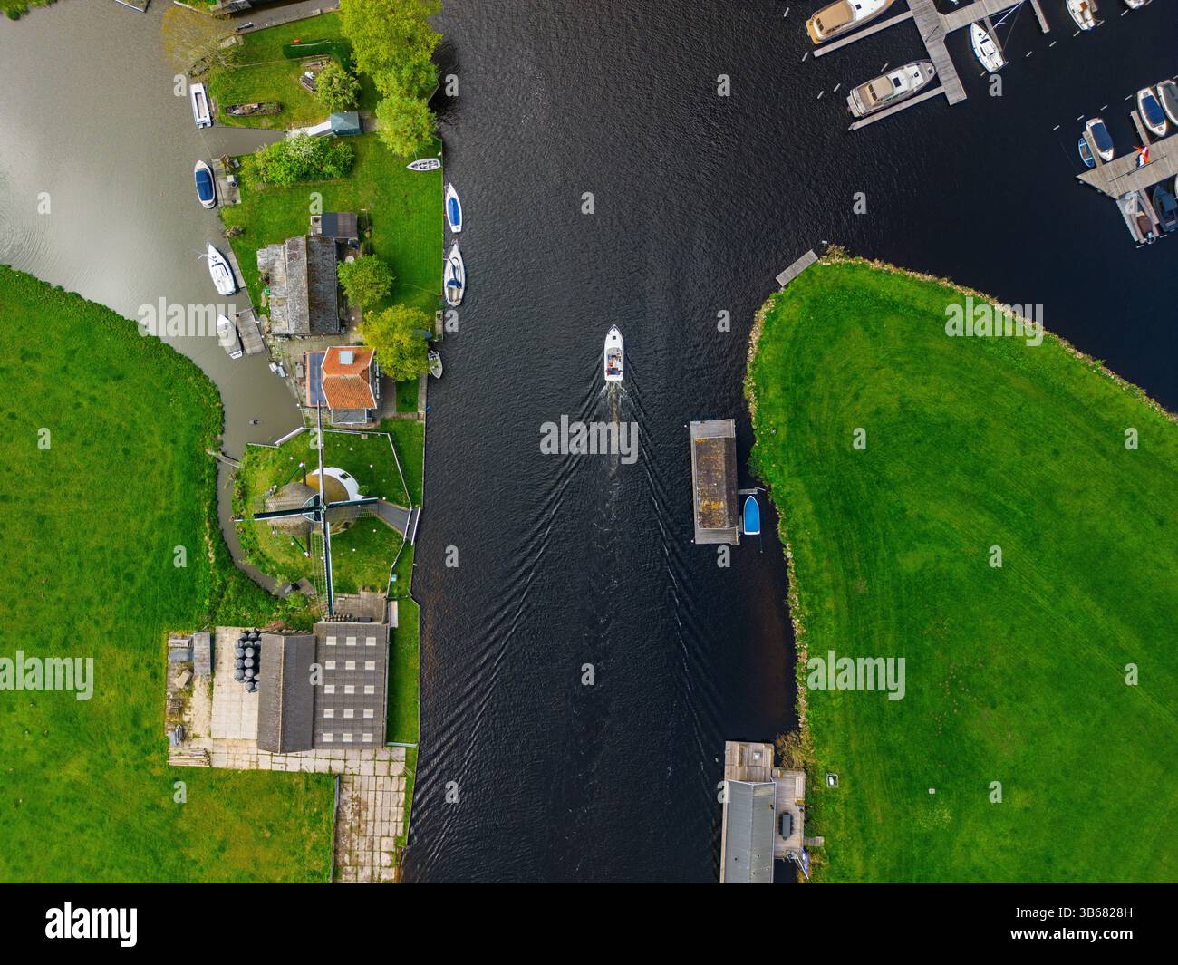 A top-down view of a marina with multiple boats docked along wooden ...