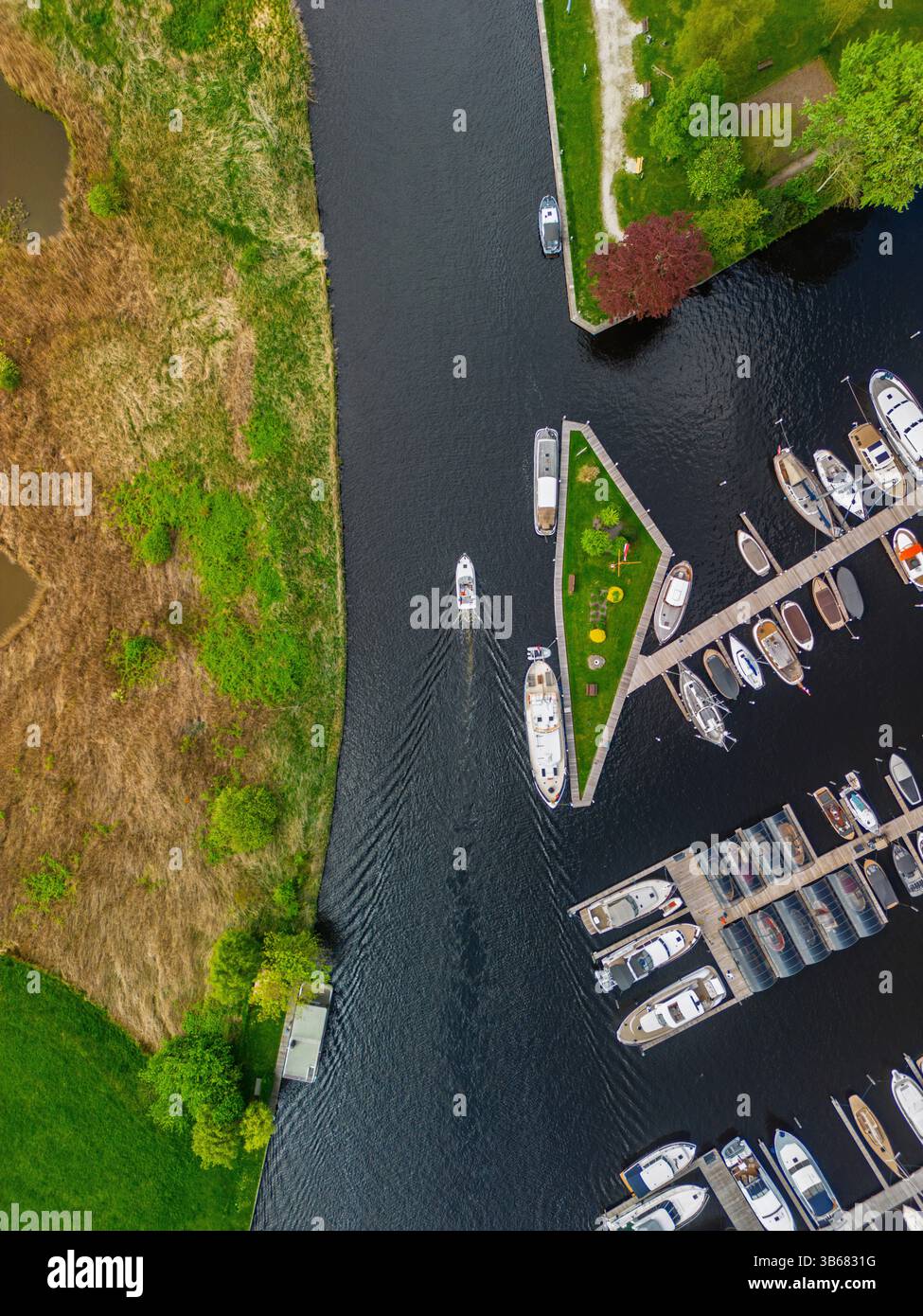 A top-down view of a marina with multiple boats docked along wooden ...