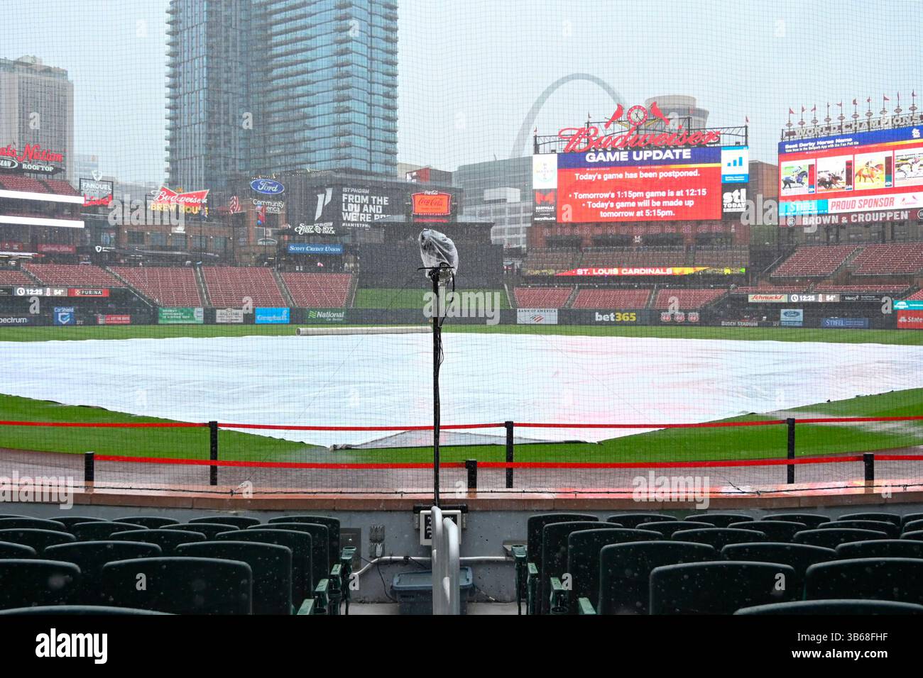 Water collects on the tarp as rain falls at Busch Stadium where the ...