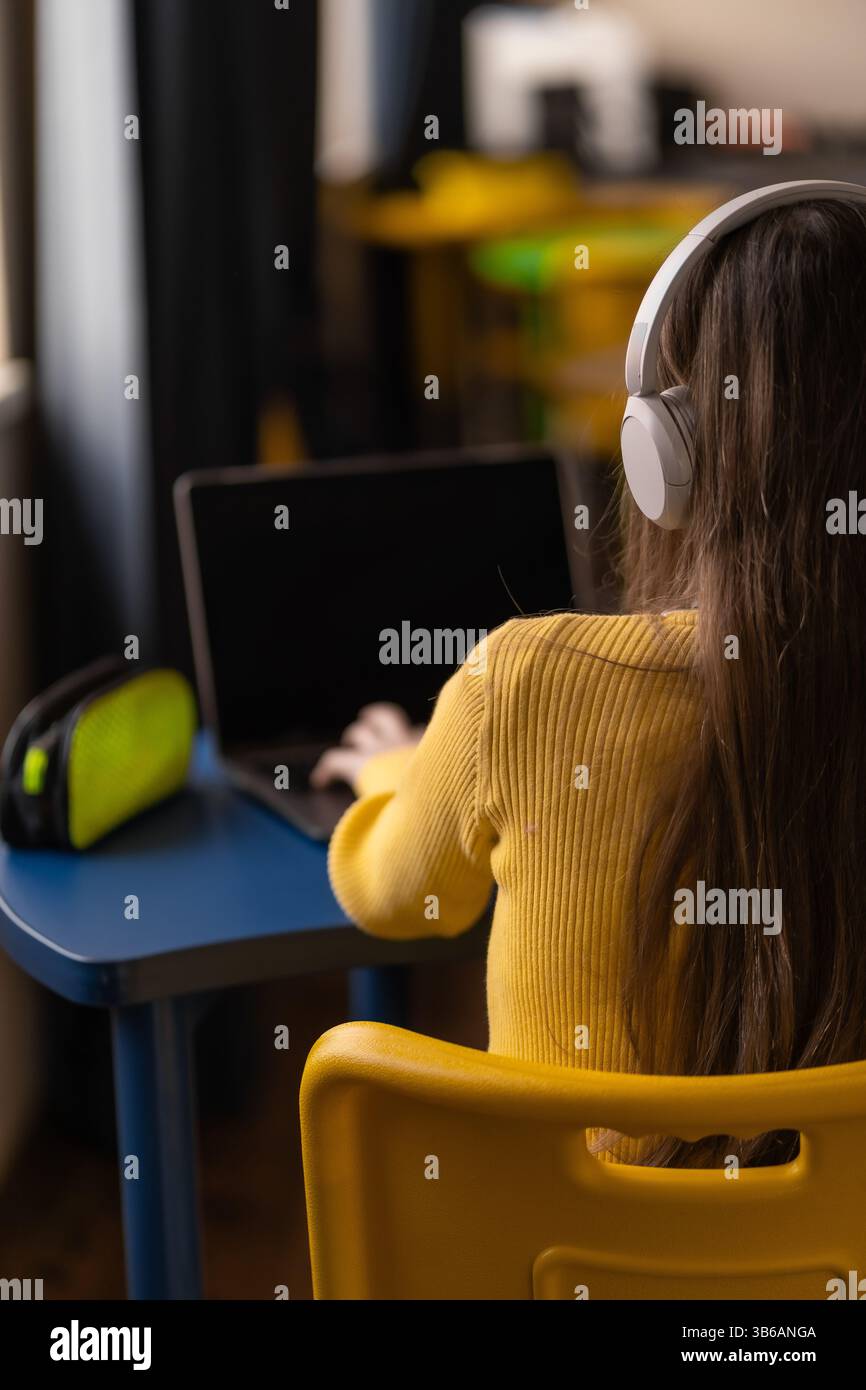 Girl in headphones learning quietly at laptop developing digital ...
