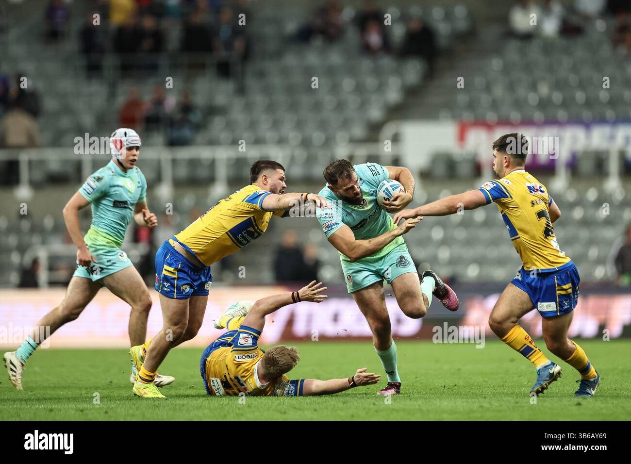 Jake Wingfield of St. Helens hands off Jack Sinfield of Leeds Rhinos ...