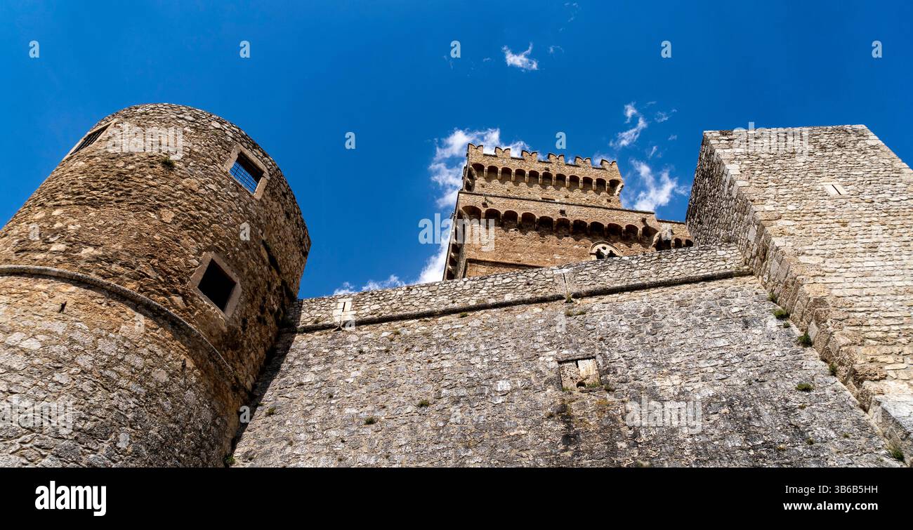 A low-angle view of a historic stone castle with a round tower and a ...