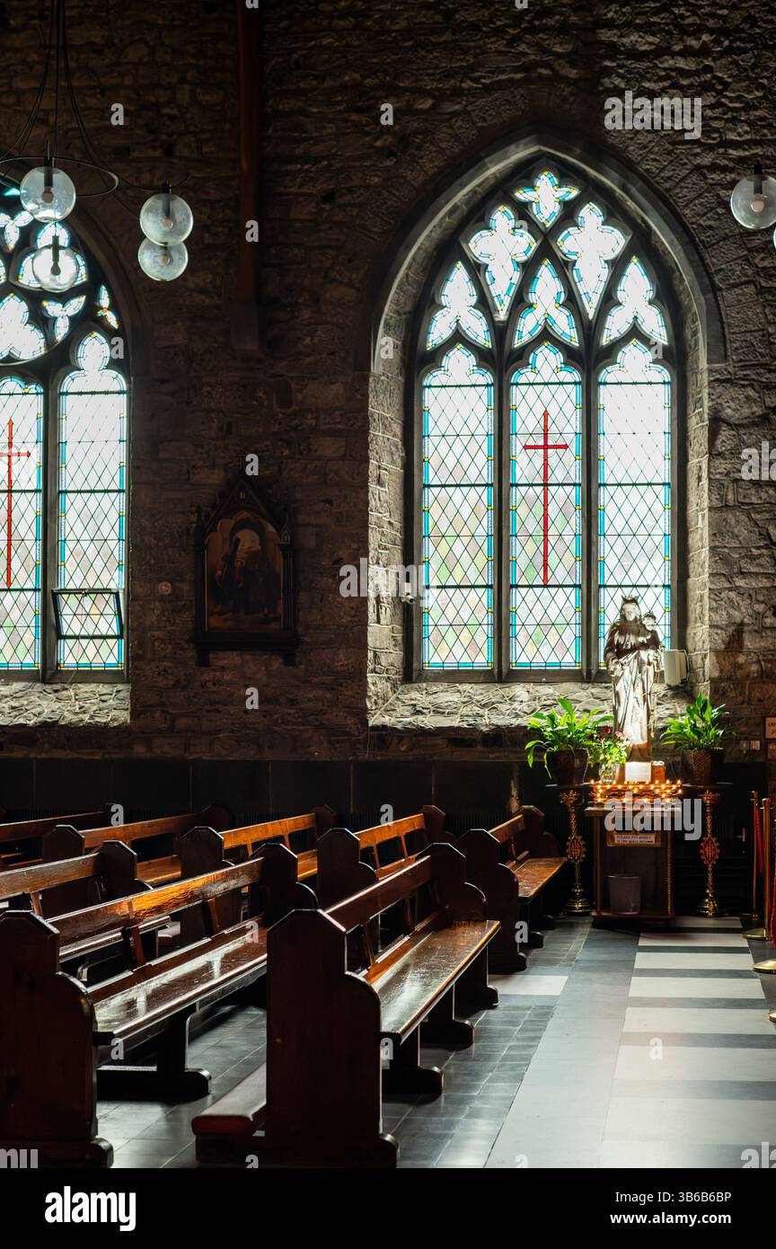 Interior view of a historic Irish church with wooden pews, gothic ...