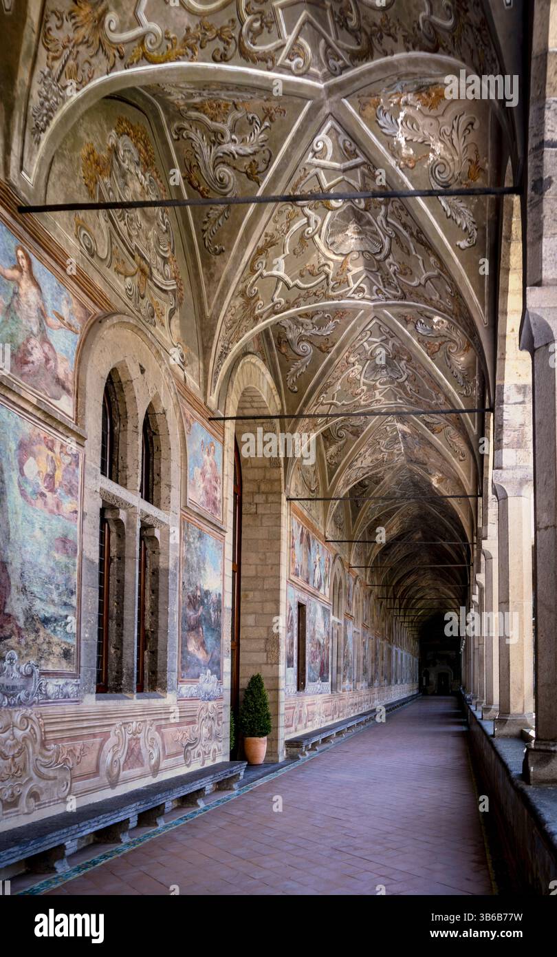 A long, beautifully decorated corridor with intricate frescoes on the ...