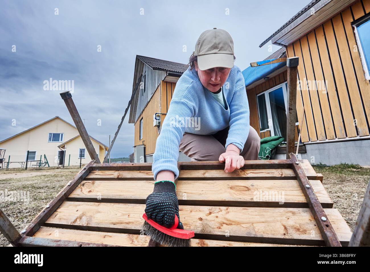 Scrubbing metal frame of garden bench, outdoor enthusiast uses wire ...