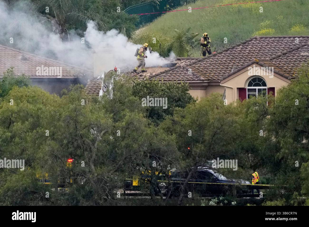 Firefighters work at the site of a plane crash in the Wood Ranch ...