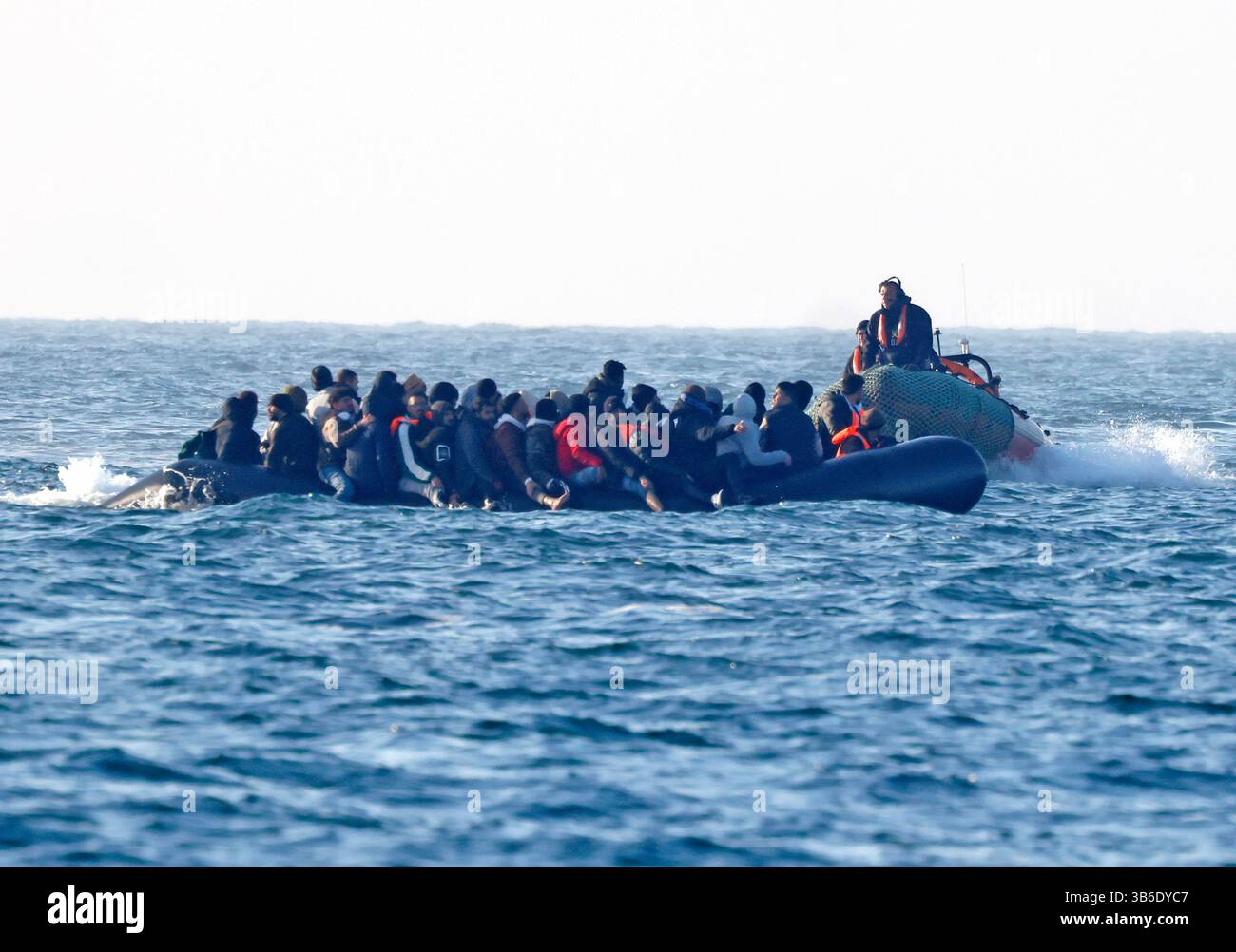 A packed migrant dinghy is seen in French territorial waters of The ...