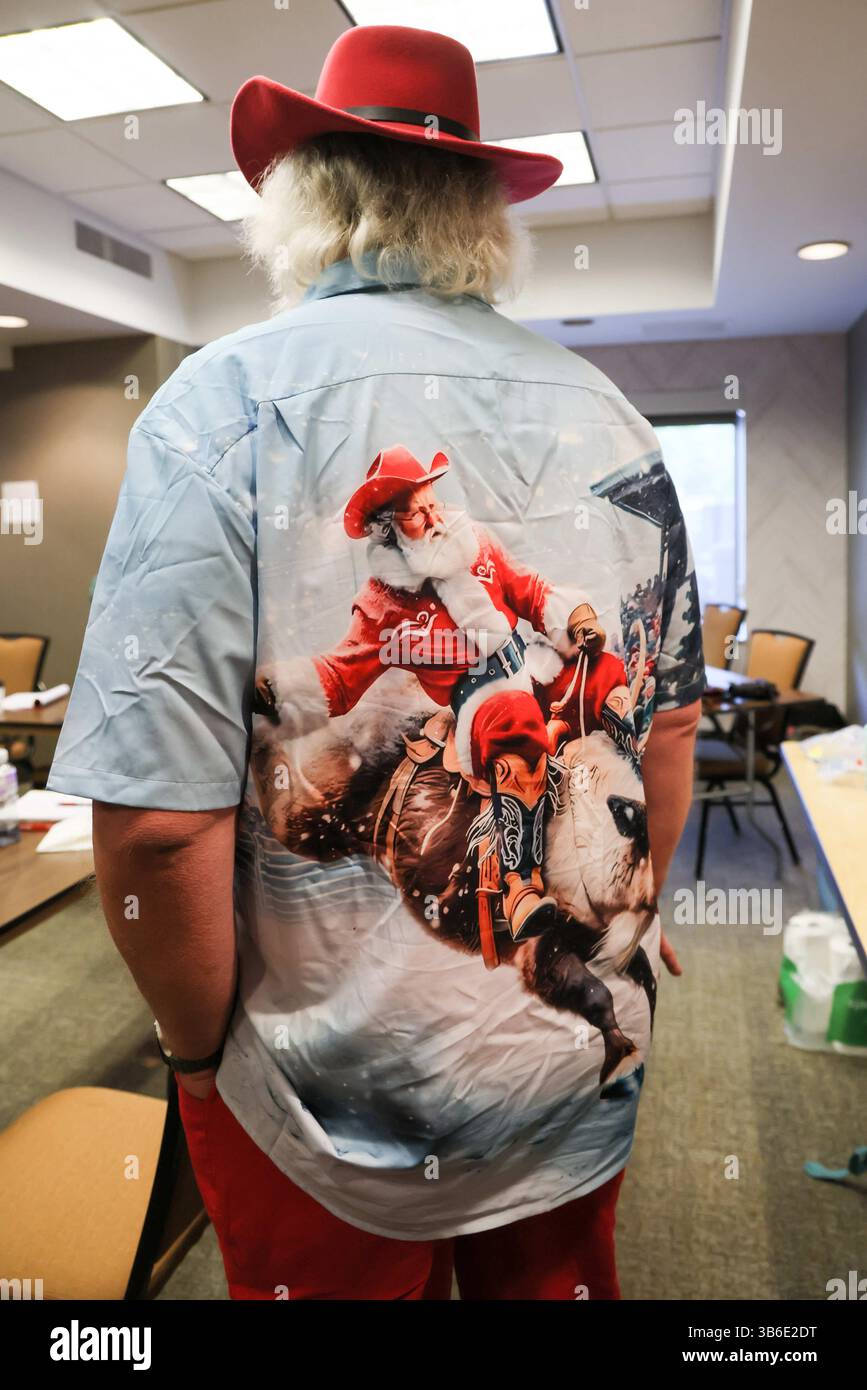 An attendee wears a Western Santa themed shirt while attending the ...