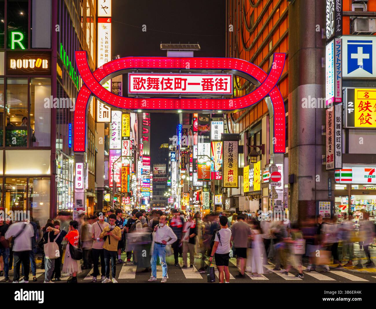 Crowds at night in front of the iconic red gate of Kabukicho Ichiban ...