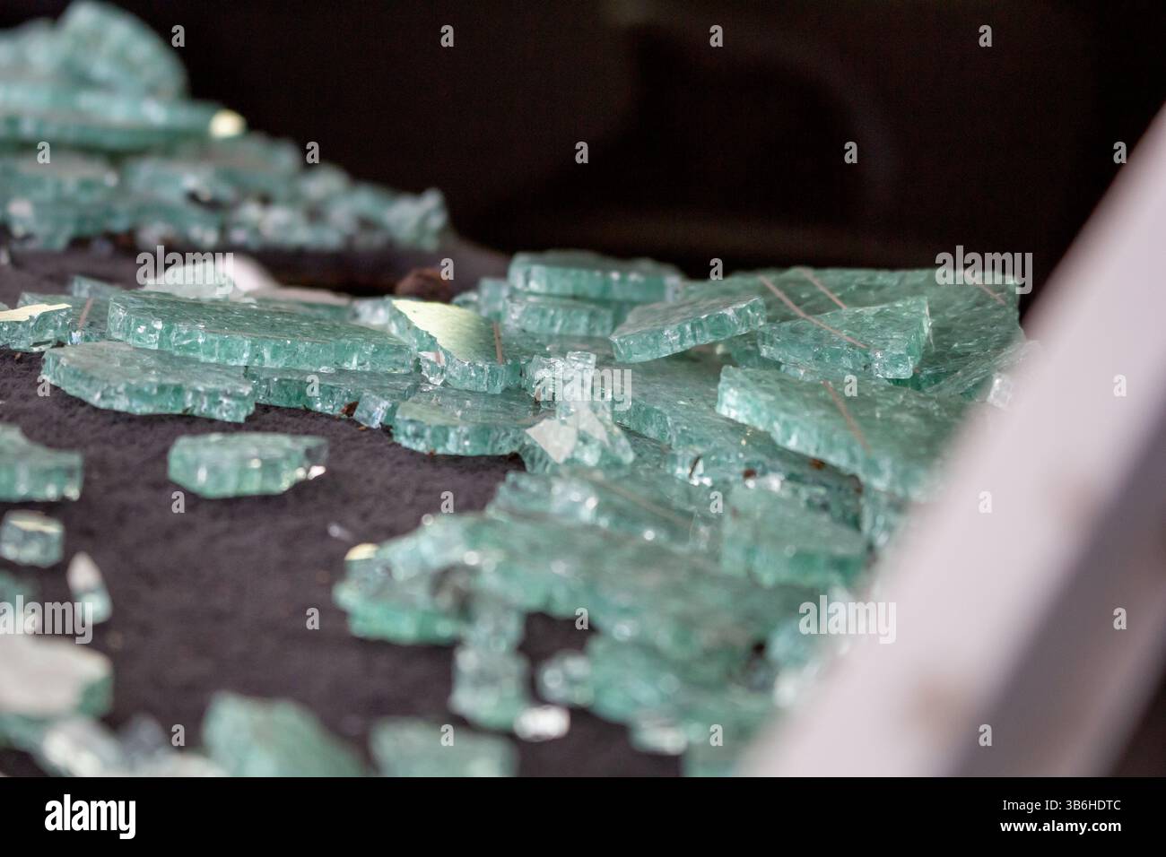 A closeup view of a shattered windshield on the dashboard area of a ...