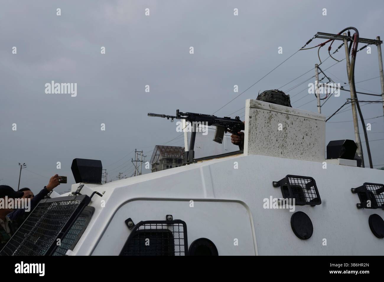 An Indian soldier guards on top of his armored vehicle as the first ...