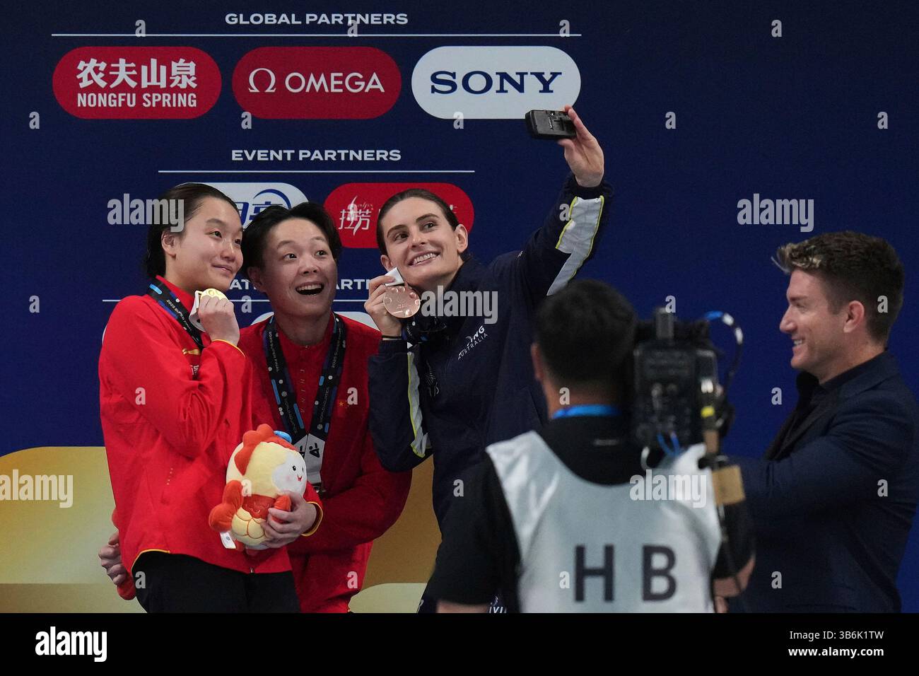 A cameraman films bronze medalist Maddison Keeney of Australia, center ...