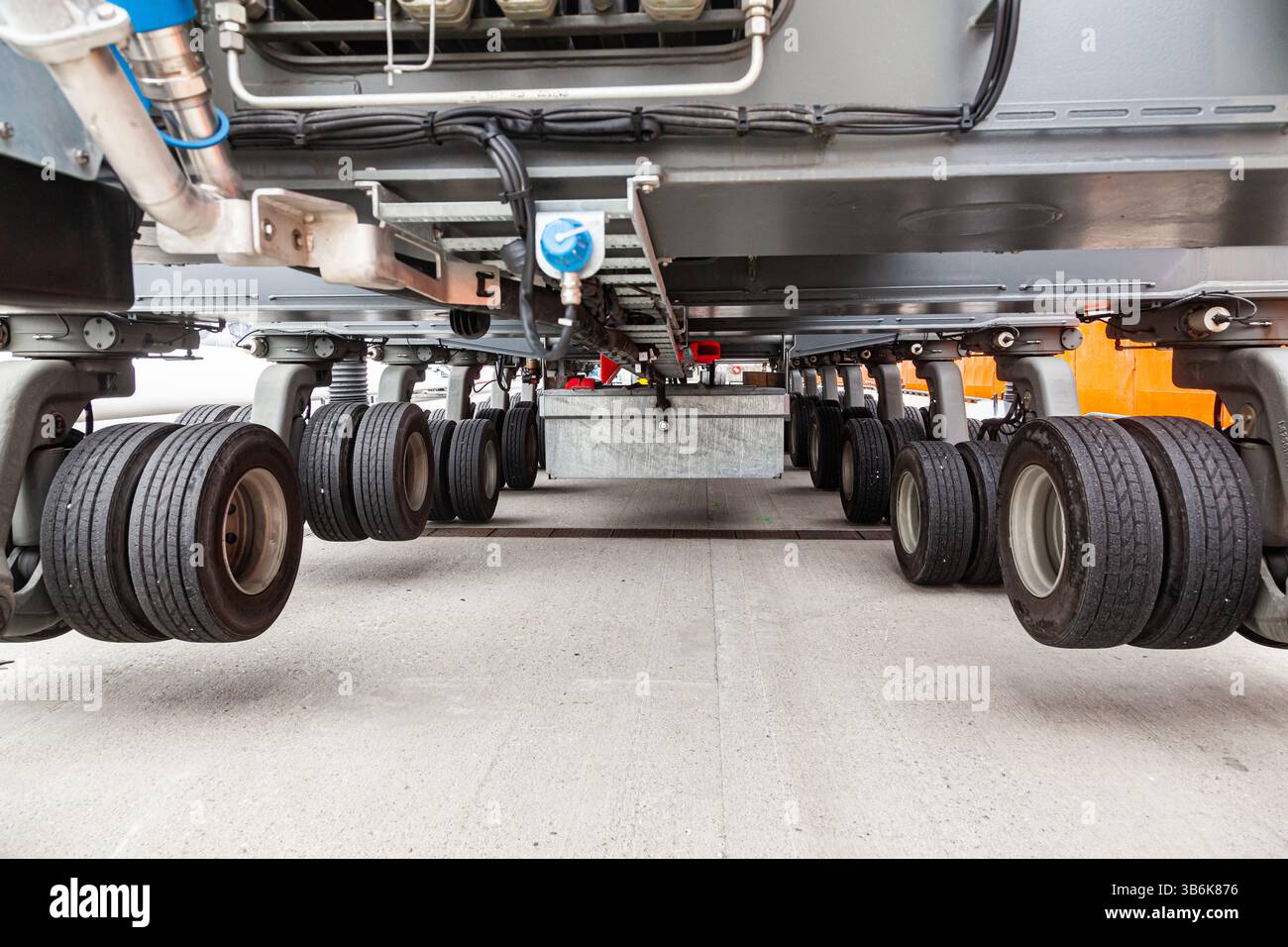A large Liebherr truck crane stands on supports in the seaport area ...