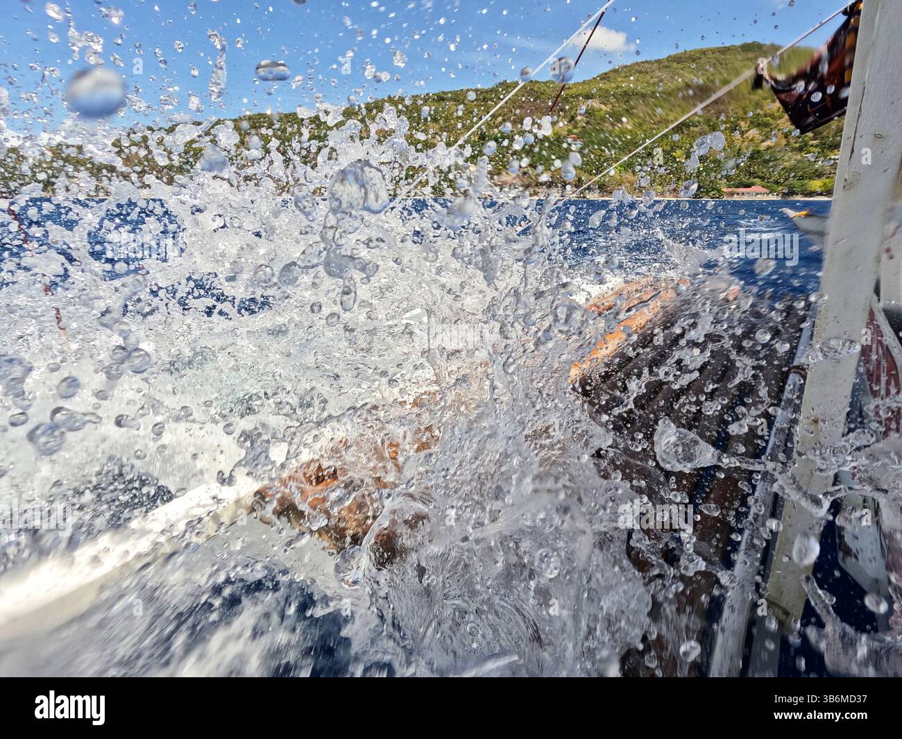 Dramatic splash of seawater captured from the side of a moving boat ...