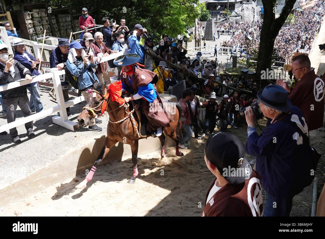 A horse carrying a young man dressed as a warrior runs up a slope ...