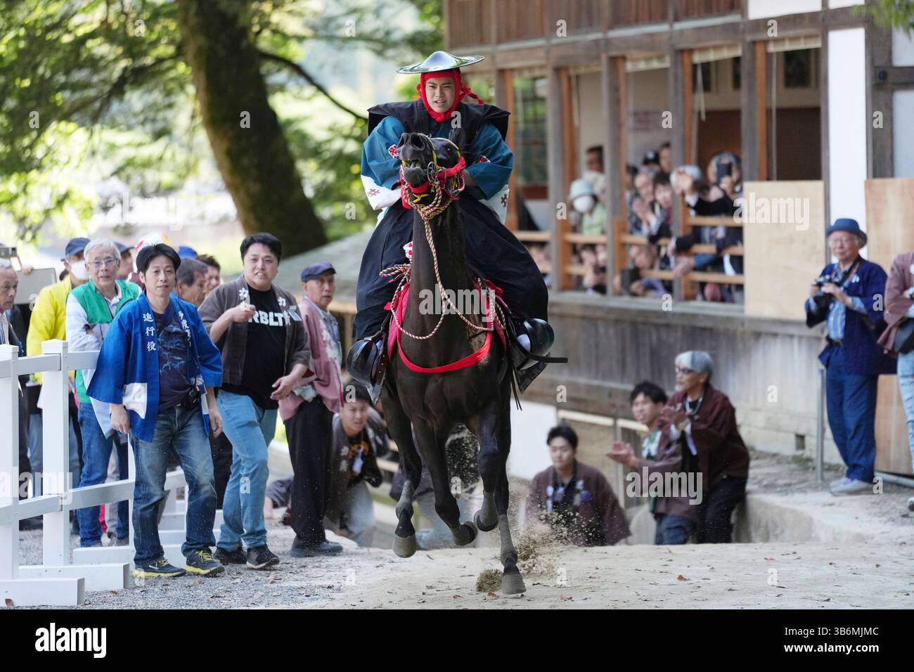 A horse carrying a young man dressed as a warrior runs up a slope ...
