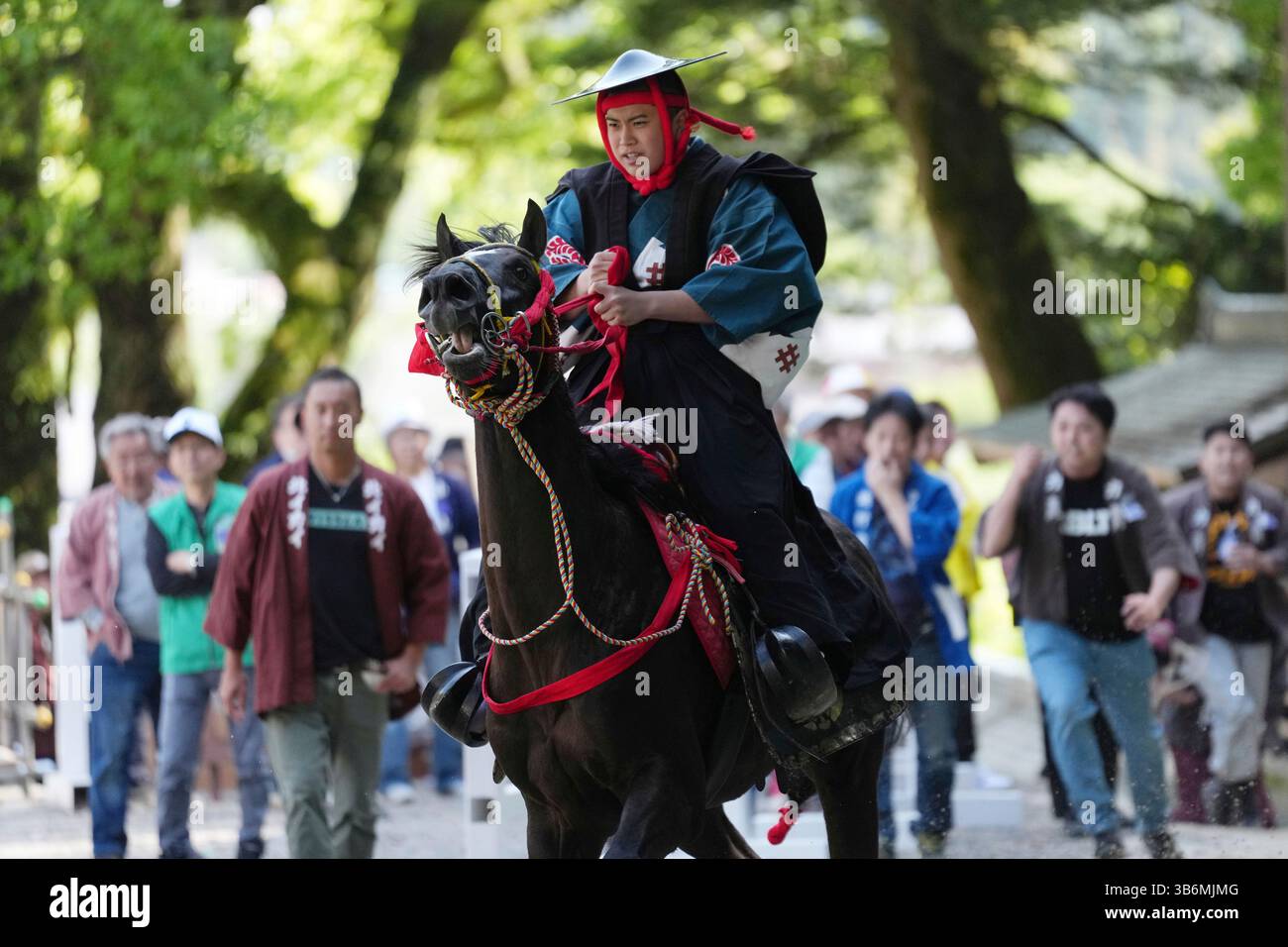 A horse carrying a young man dressed as a warrior runs up a slope ...